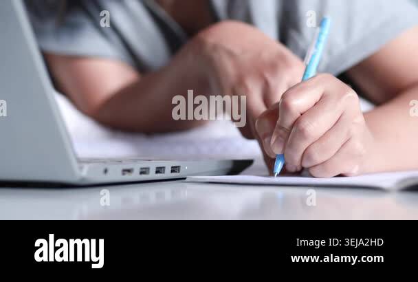 Writing notes beside a laptop, ideal for education, online learning ...
