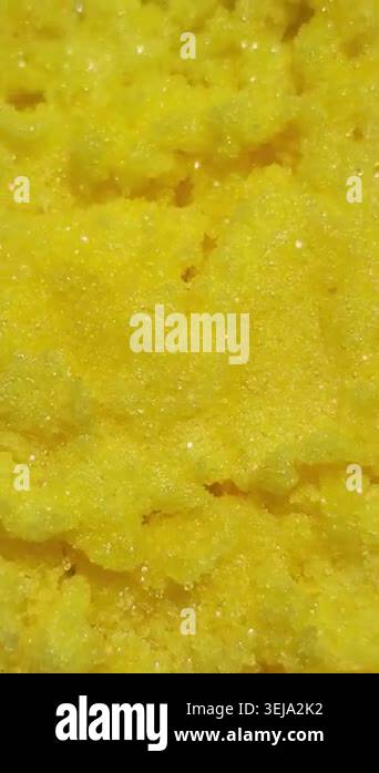 Close-up macro view of bright yellow shimmering salt body scrub texture ...