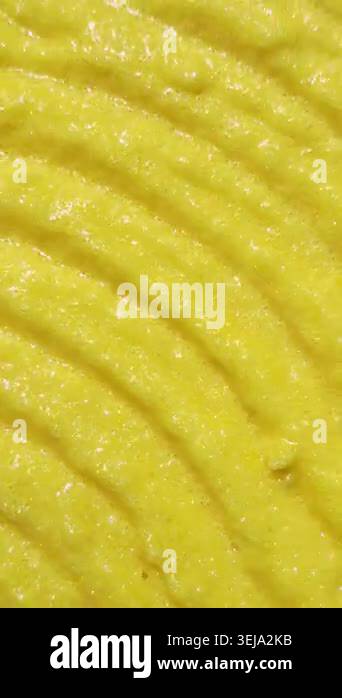 Close-up macro view of bright yellow shimmering salt body scrub texture ...