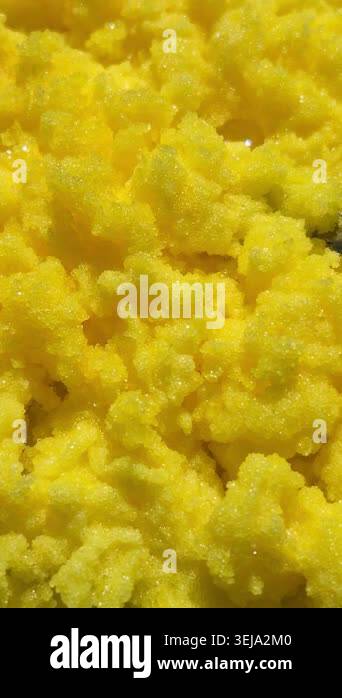 Close-up macro view of bright yellow shimmering salt body scrub texture ...
