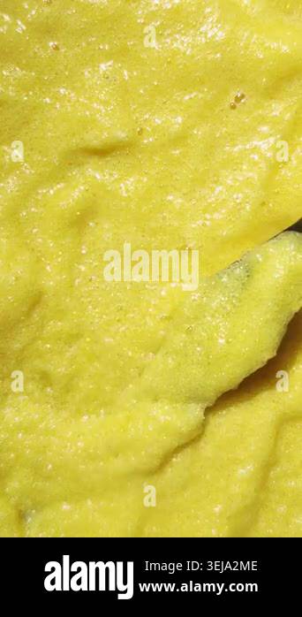 Close-up macro view of bright yellow shimmering salt body scrub texture ...