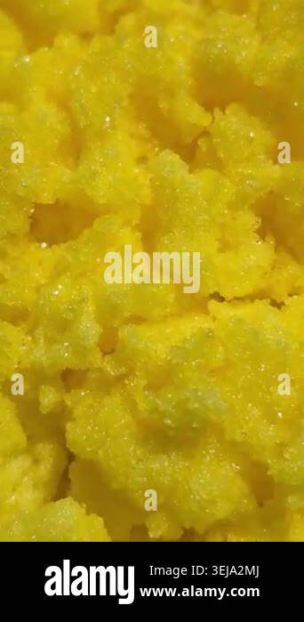 Close-up macro view of bright yellow shimmering salt body scrub texture ...