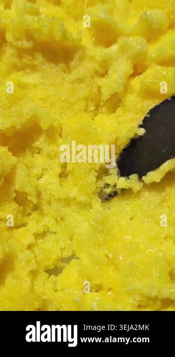 Close-up macro view of bright yellow shimmering salt body scrub texture ...