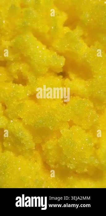 Close-up macro view of bright yellow shimmering salt body scrub texture ...