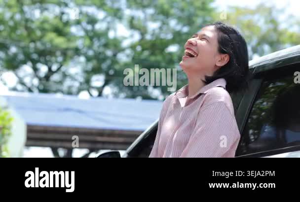 Happy Thai Asian woman laughing beside a car outdoors, Businesswoman in ...