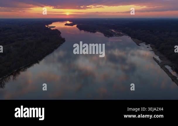 Breathtaking aerial view of serene river at golden sunset with forested ...