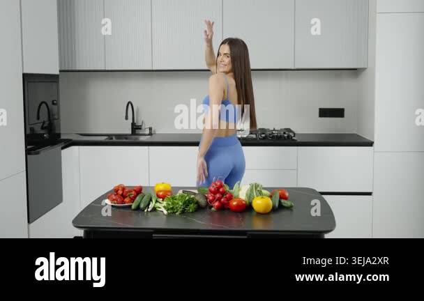 Cheerful fit woman dancing in the kitchen with fresh vegetables Stock ...