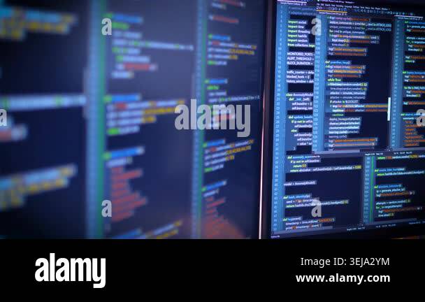 Close up computer monitors displaying fictional programming code and ...