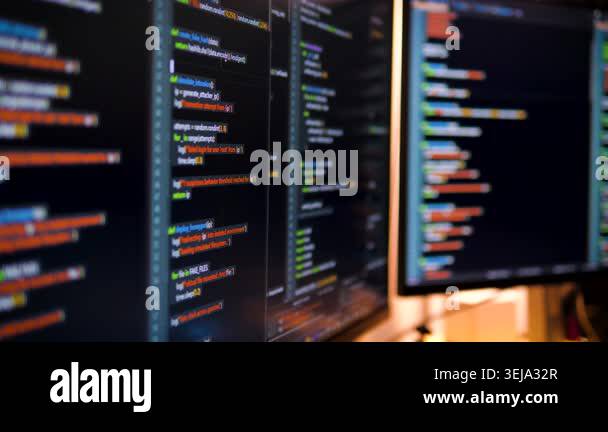 Close up computer monitors displaying fictional programming code and ...