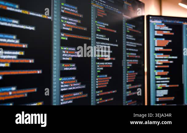 Close up computer monitors displaying fictional programming code and ...