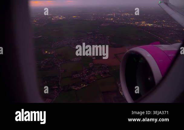 Aircraft takeoff over evening landscape from passenger window ...