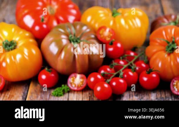 variety of fresh heirloom and cherry tomatoes on rustic wooden ...