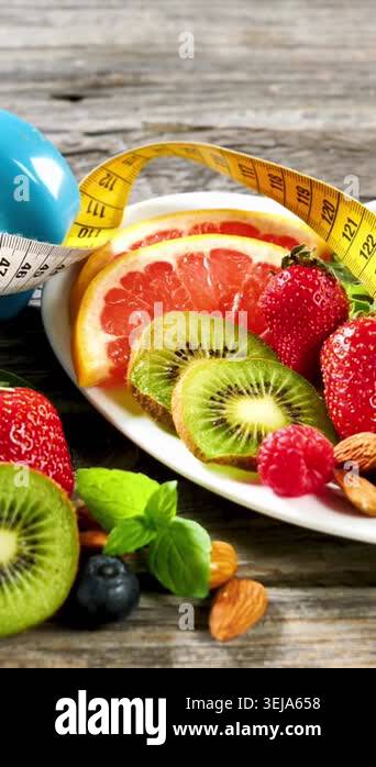 healthy diet plate with fresh fruits almonds, measuring tape and ...