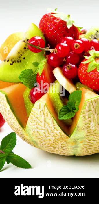 close up of fresh fruit salad with red currants, strawberries, kiwi and ...