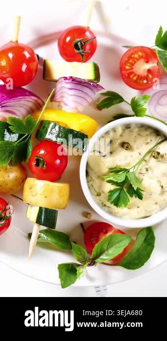 close up of fresh vegetable skewers with cherry tomatoes and dipping ...