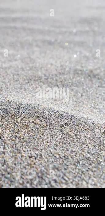 slow motion of sand blowing in the wind on a beach dune, grey sand ...