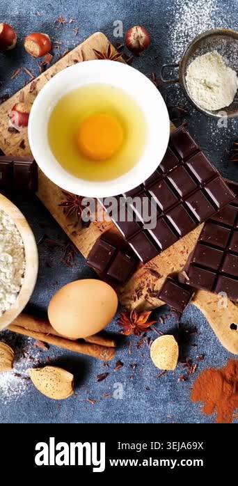 top view of. baking ingredients with raw egg, dark chocolate bar, flour ...