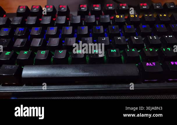 Close up of a black mechanical gaming keyboard with vibrant RGB LED backlit lighting effects ...