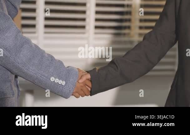 two young businessmen shaking hands in modern office Stock Video ...