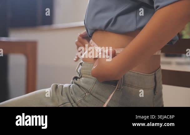 close up of a young woman measuring her waist with measuring tape Stock ...