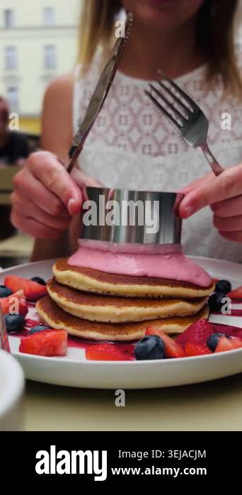 Woman Cutting Fluffy Pancakes with Pink Cream and Fresh Berries. Close ...