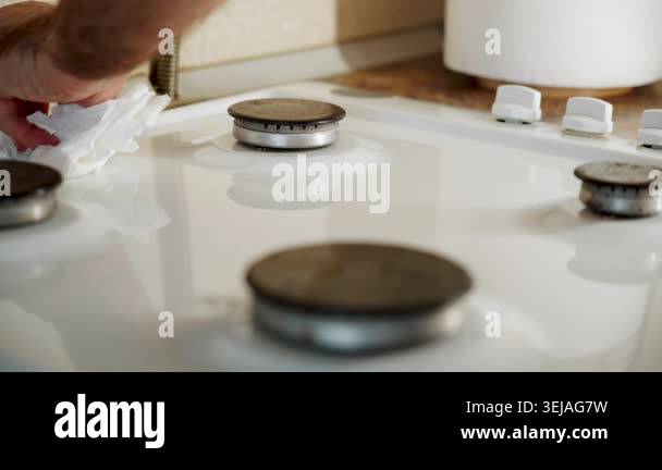 Clean white gas stove cooktop and metal burners sparkle, highlighting a ...