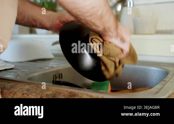 Close up of hands placing a brown piece of clothing into a clean ...