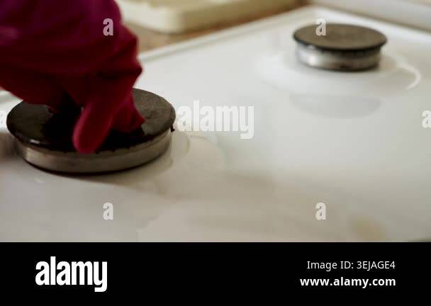 A person thoroughly cleans a dirty kitchen stovetop, wearing a vibrant ...
