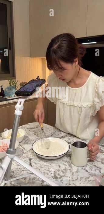 Focused asian woman influencer recording cooking vlog using smartphone ...