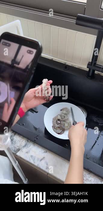 Focused asian woman influencer enthusiastically recording creative ...