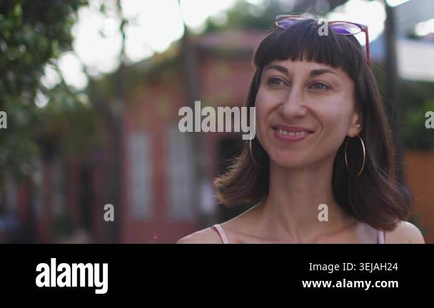 A smiling woman strolls through the beautiful streets of Tel Aviv ...