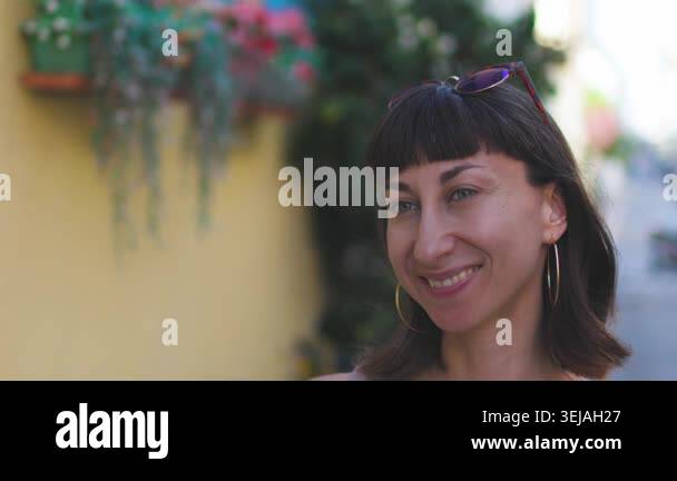 A smiling woman strolls through the beautiful streets of Tel Aviv ...