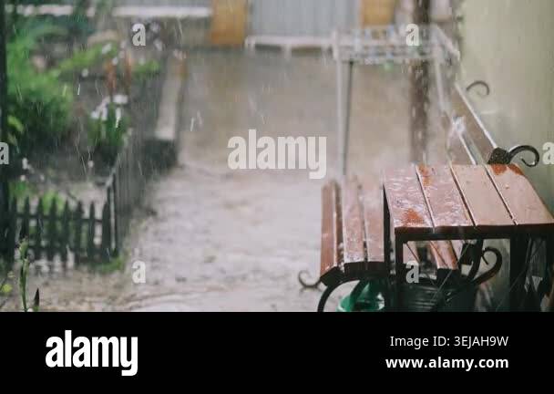 Strong rainstorm with hail falling in residential backyard near wooden ...