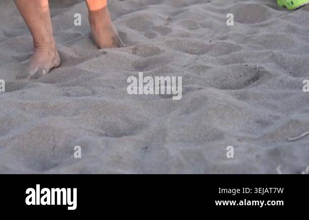 sea foam and sea wave, Barefoot person walking on wet sand beside the ...