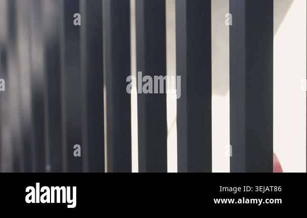 Close-up of hands exchanging Indonesian rupiah through prison bars ...
