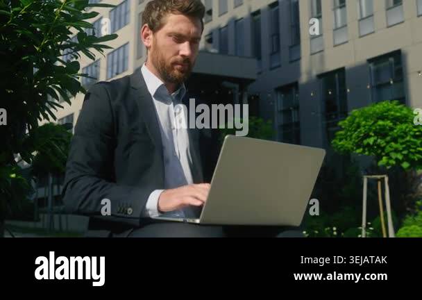 Serious focused Caucasian business man working laptop outdoors city ...