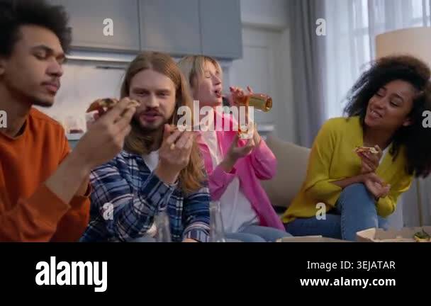 Multiracial happy young friends men women eating pizza fast food at ...