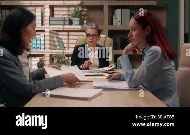 Business team females women work with papers talking in office ...