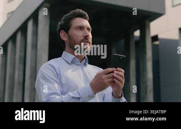 Joyful smiling Caucasian mature business man using smartphone in city ...