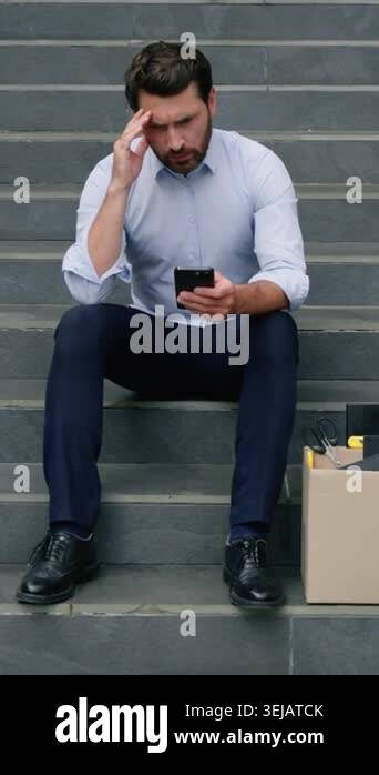 Upset Caucasian mature businessman looking at mobile phone unemployment ...