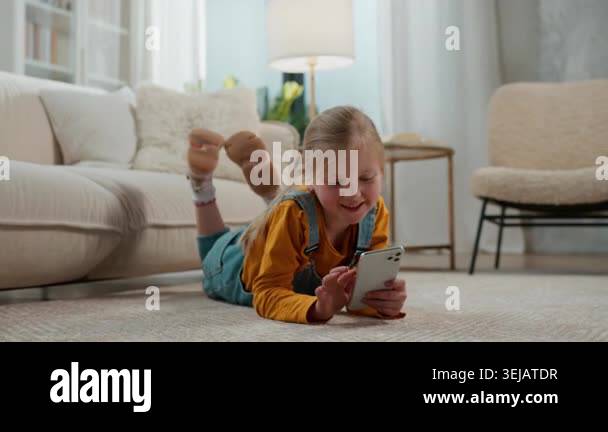 Cute carefree little Caucasian kid girl child daughter typing mobile ...