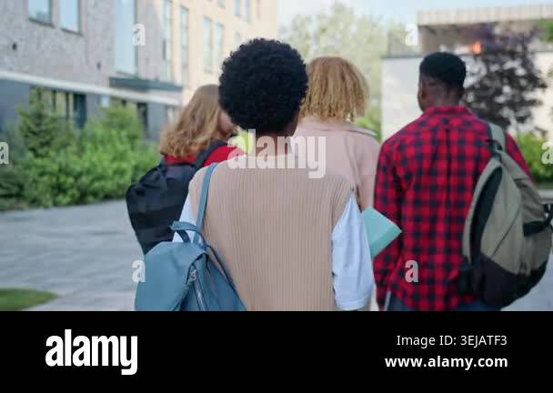 Back view four multiracial students walking in city African American ...