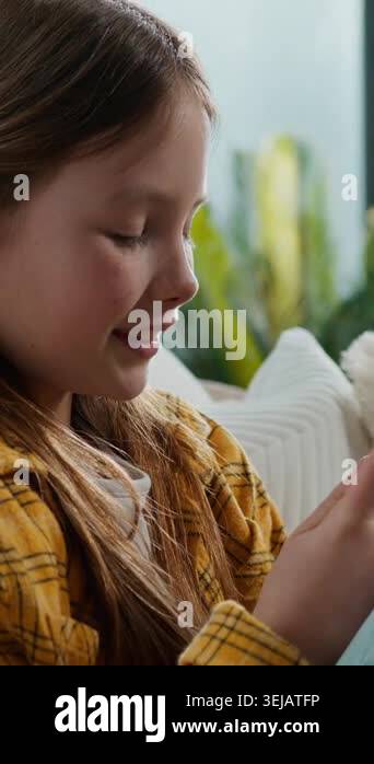 Little teen Caucasian kid girl using mobile phone app smiling satisfied ...
