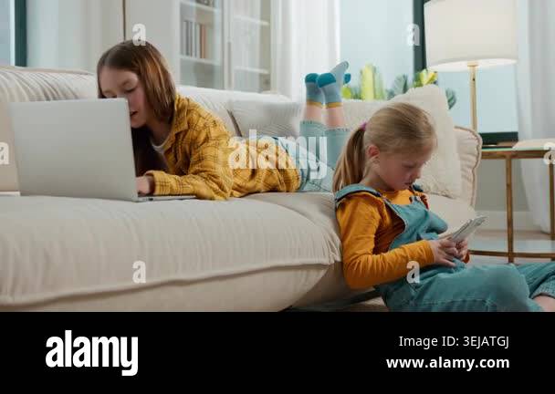 Two Caucasian kids girls modern technology addict generation looking in ...