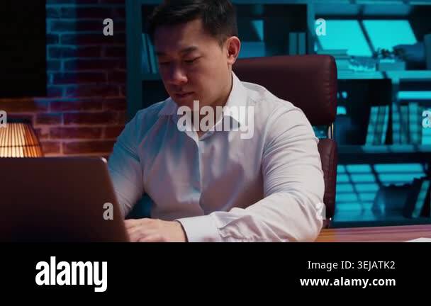 Productive Asian business man typing laptop looking at wristwatch ...