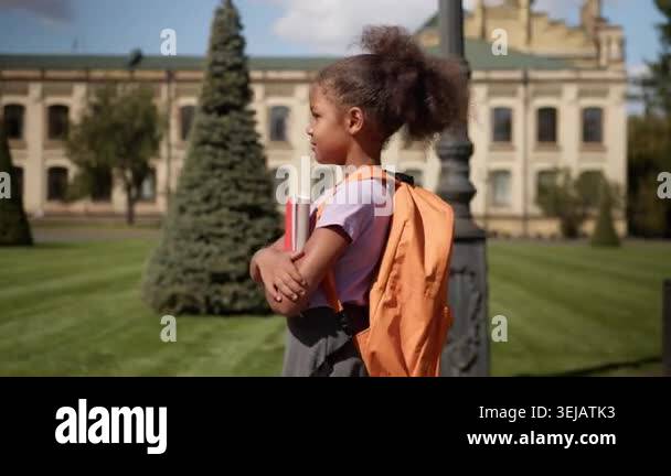 Side view African American little girl child going outdoor school ...