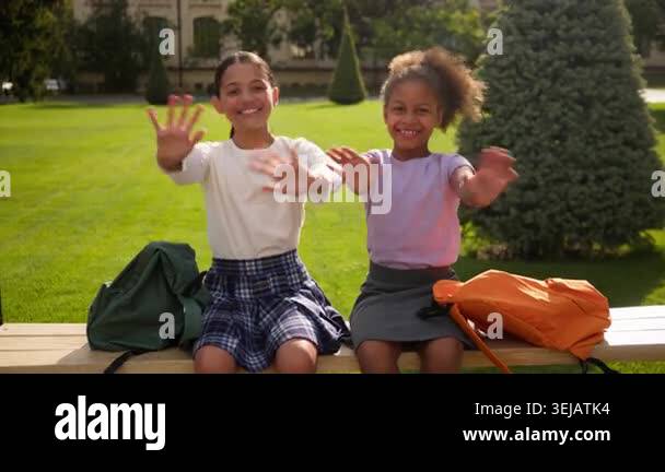 Happy little girls African American schoolgirls laugh waving hands ...