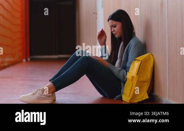Caucasian frustrated female girl school student looking at mobile phone ...