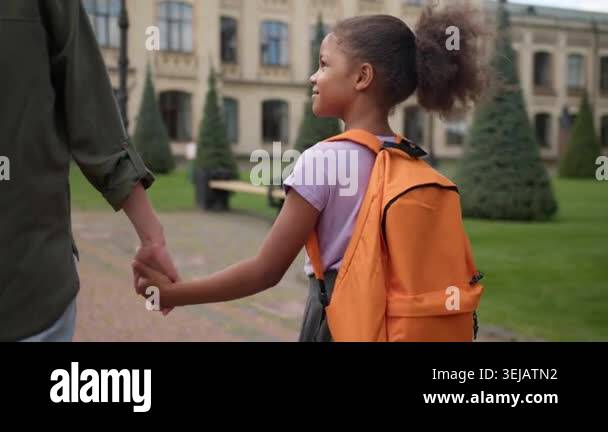 Mom and African American daughter going to school together holding ...