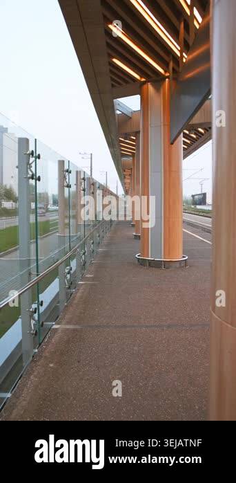 Empty railway station platform featuring vertical wooden pillars and ...